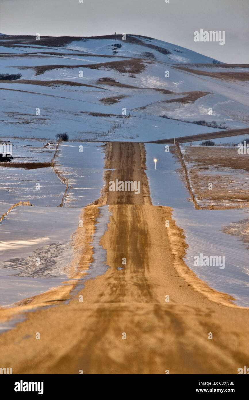 Sunset winter in the Prairie with gravel road and hills Stock Photo - Alamy