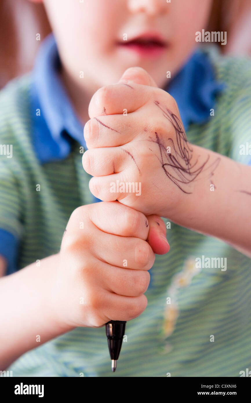Childs hands holding pen with ink on the hands Stock Photo - Alamy