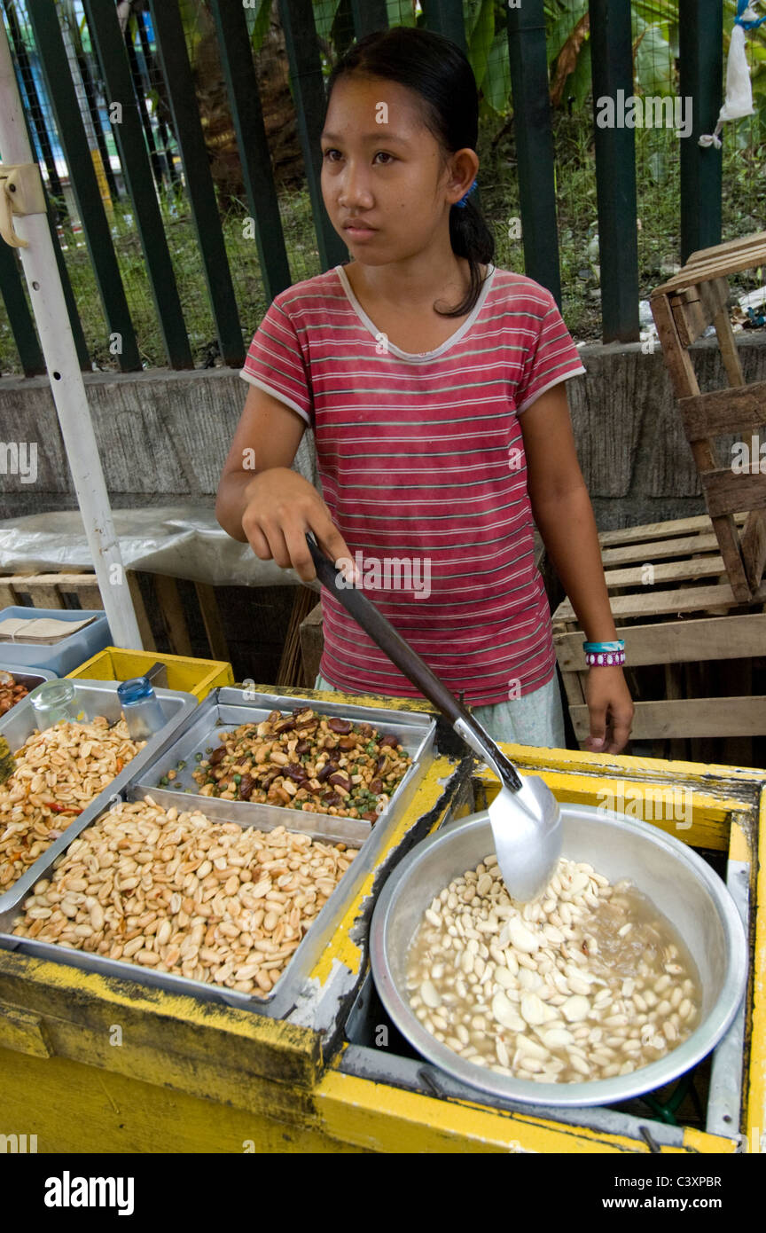 A woman cooks nuts at a street side stand Stock Photo - Alamy