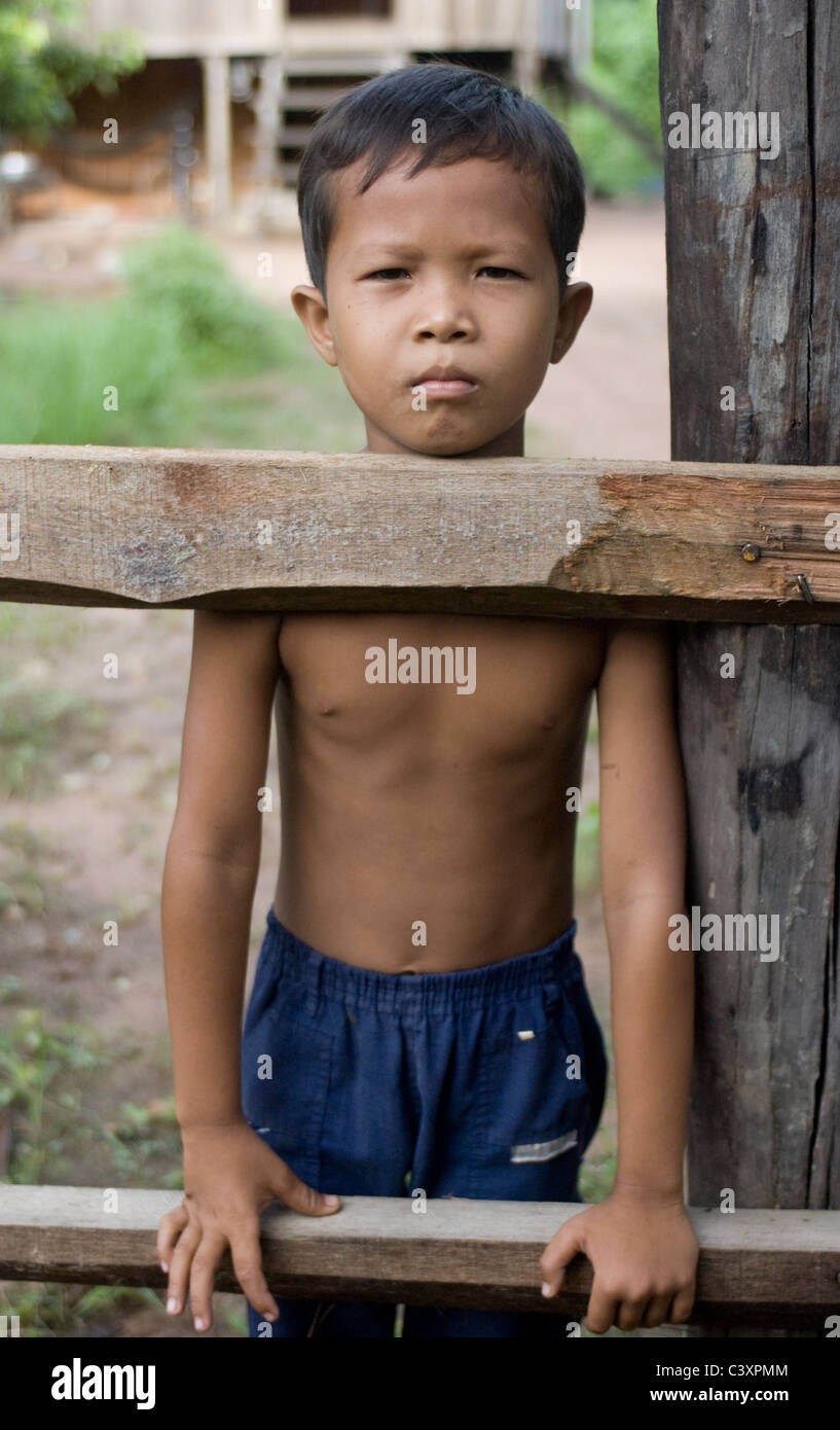 A boy stands by a fence Stock Photo - Alamy
