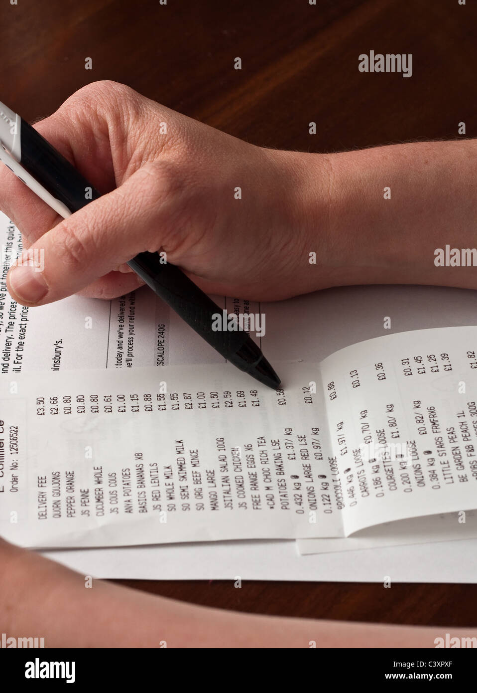 Lady checking a receipt Stock Photo - Alamy