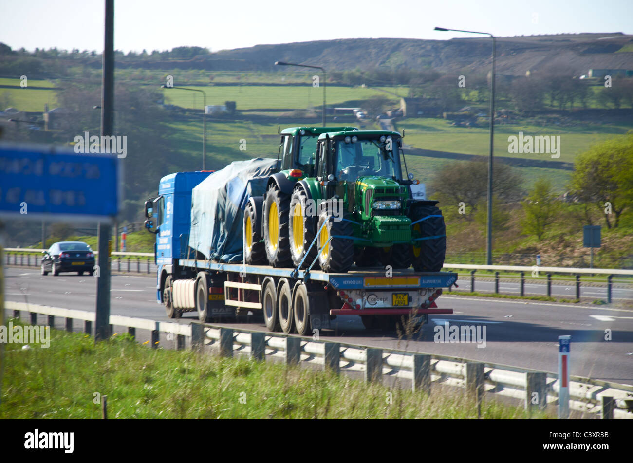 Low loader carrying tractors on the M62 Stock Photo - Alamy