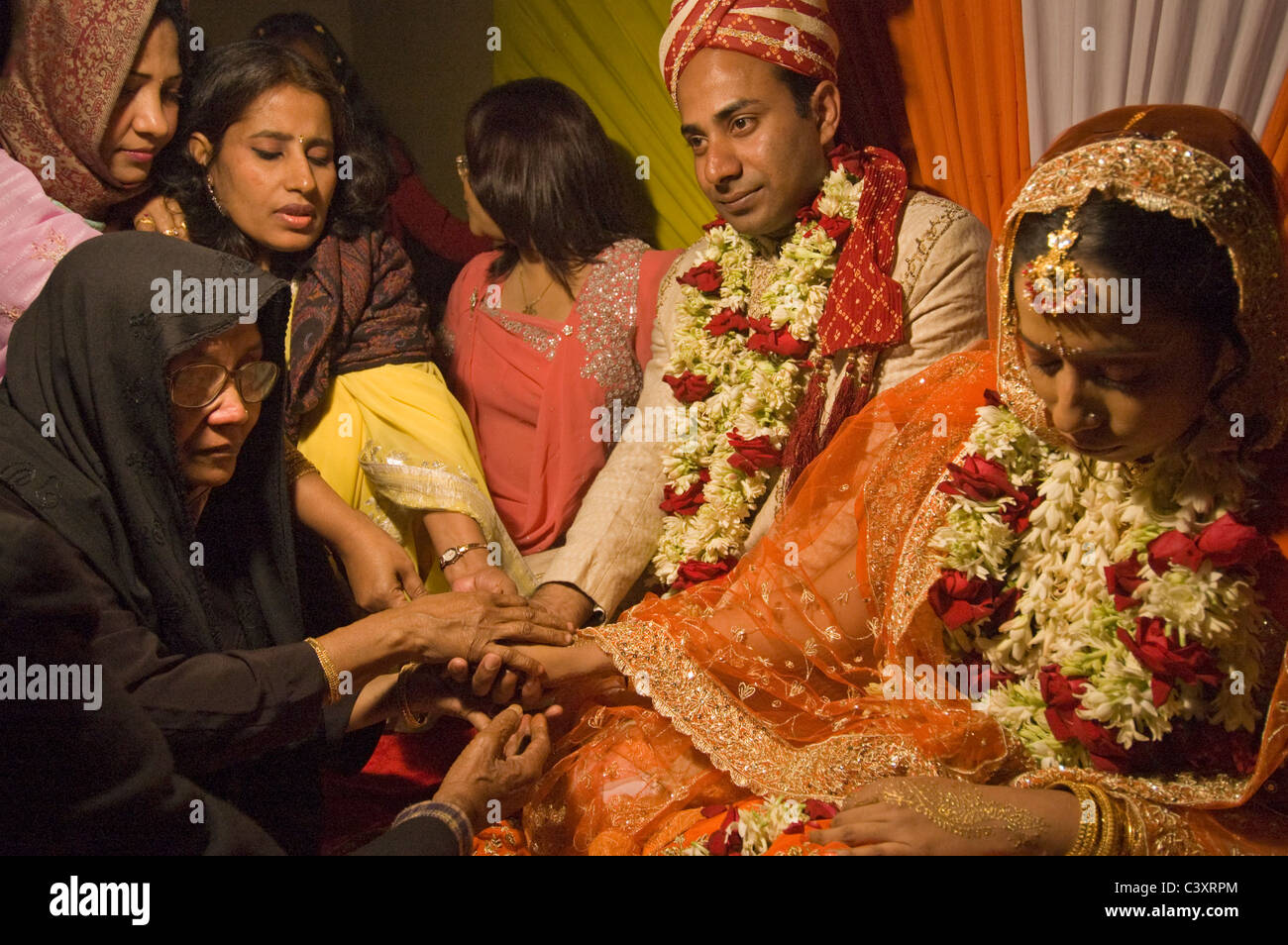 The bride and groom with the groom's mother during a muslim wedding ...