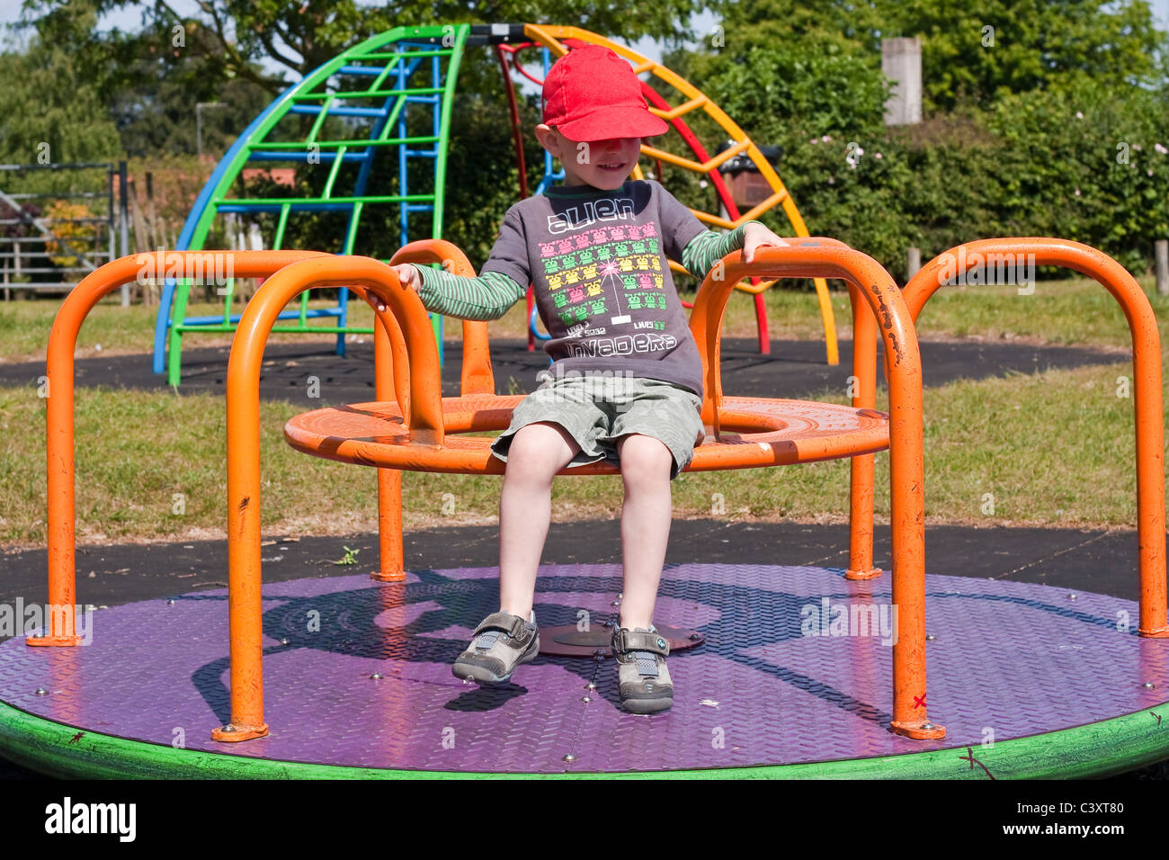 Young child playing on a roundabout in a playground in the UK Stock ...