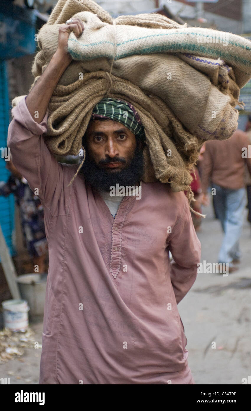 A man carries a load in Old Dhaka Stock Photo - Alamy