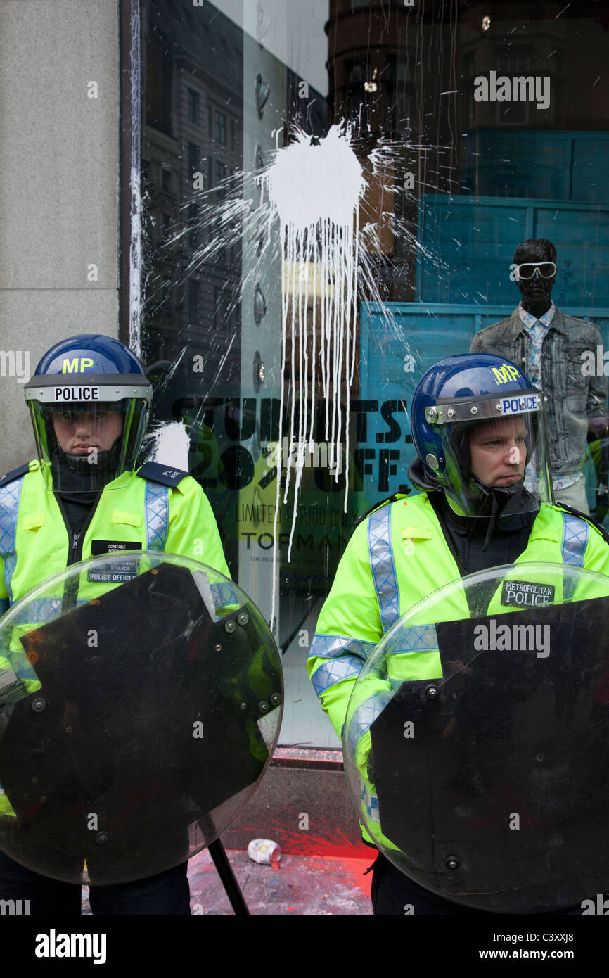 Surrounded by paint splashes, Police in riot gear stand in front of a ...