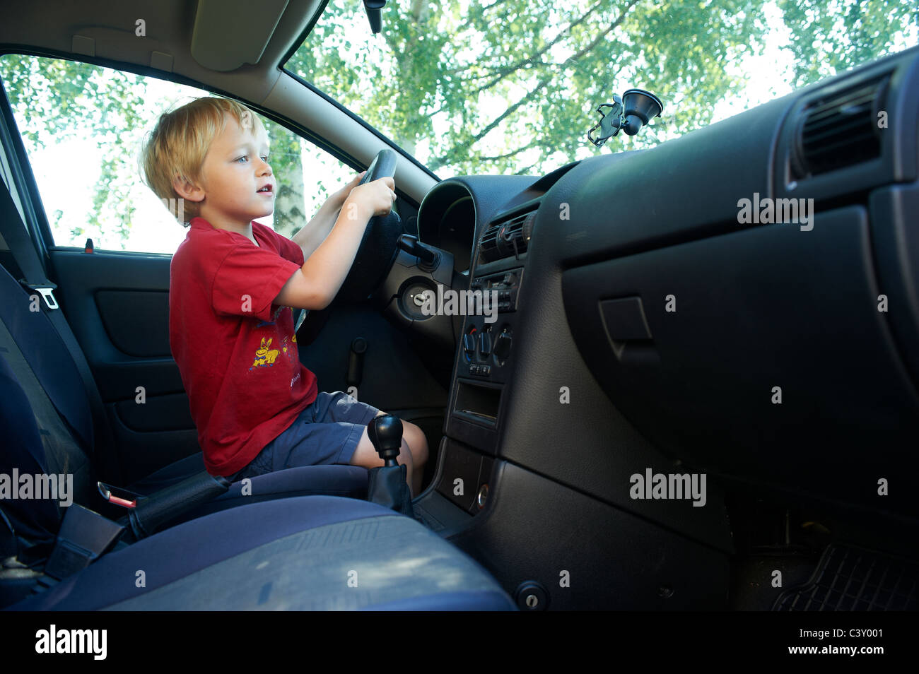 Child blond boy driving real car Stock Photo - Alamy