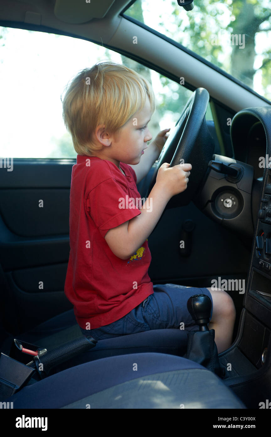 Child blond boy driving real car Stock Photo - Alamy