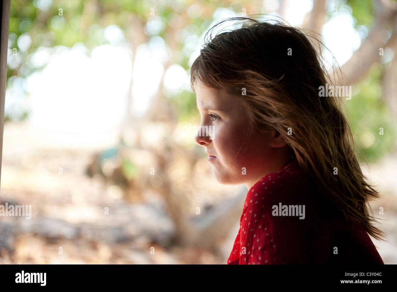 little girl looking off into distance through window Stock Photo - Alamy