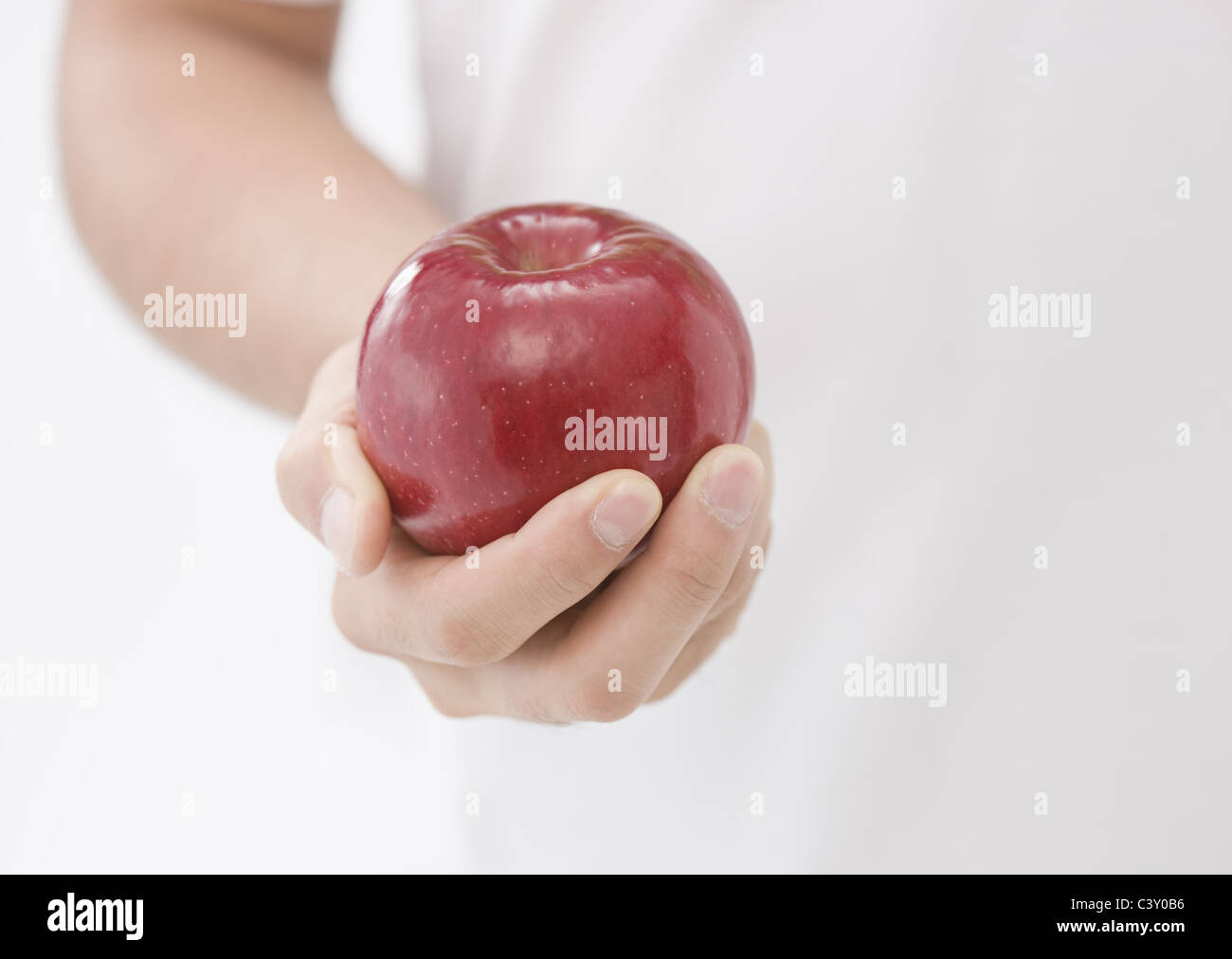 Man's hand holding apple Stock Photo - Alamy