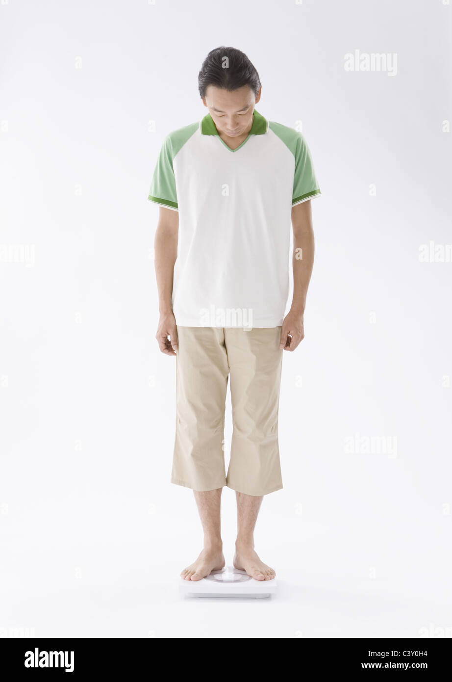 Man standing on scale Stock Photo - Alamy