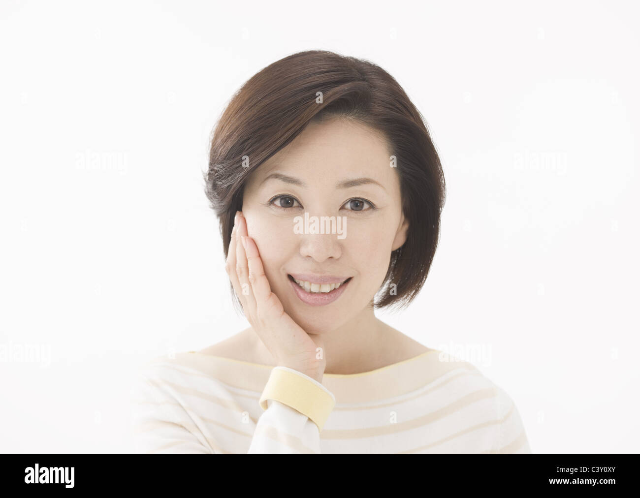 Woman with hand on cheek Stock Photo - Alamy
