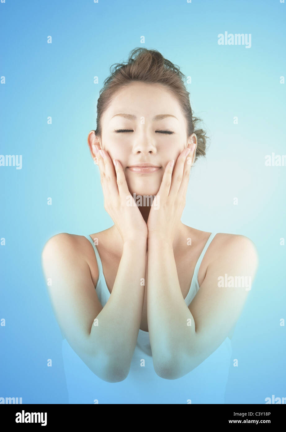 Young woman with hands on cheeks Stock Photo - Alamy