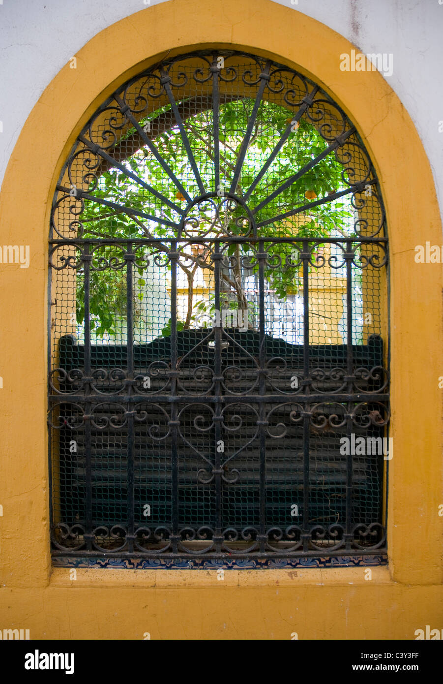 Looking through a yellow framed archway to a courtyard containing an ...