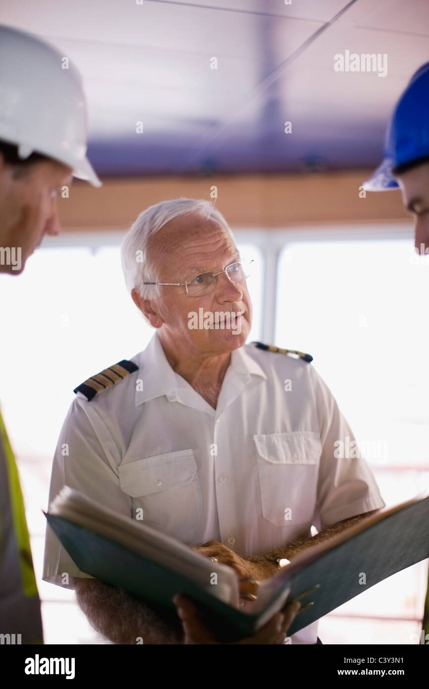 Captain of a ship talking to workers Stock Photo - Alamy