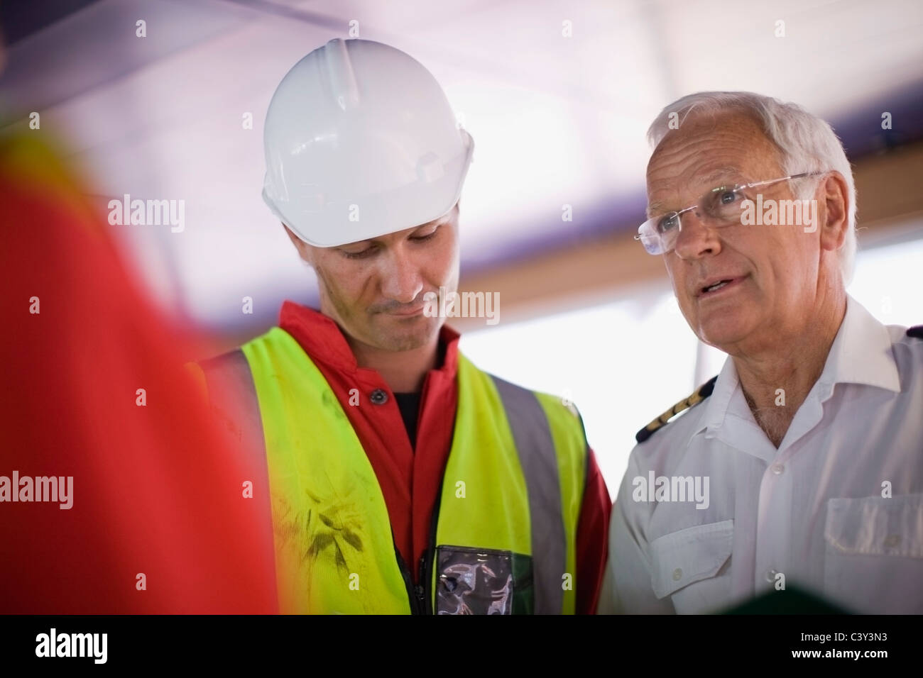 Captain of a ship talking to workers Stock Photo - Alamy