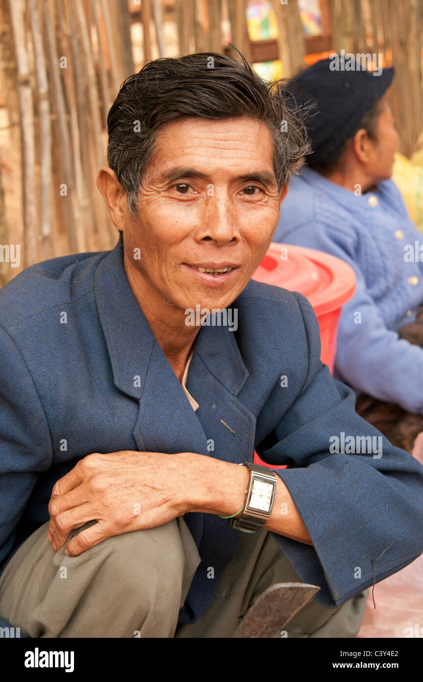 A Lao village man smiles at the camera in a market North Eastern Laos ...