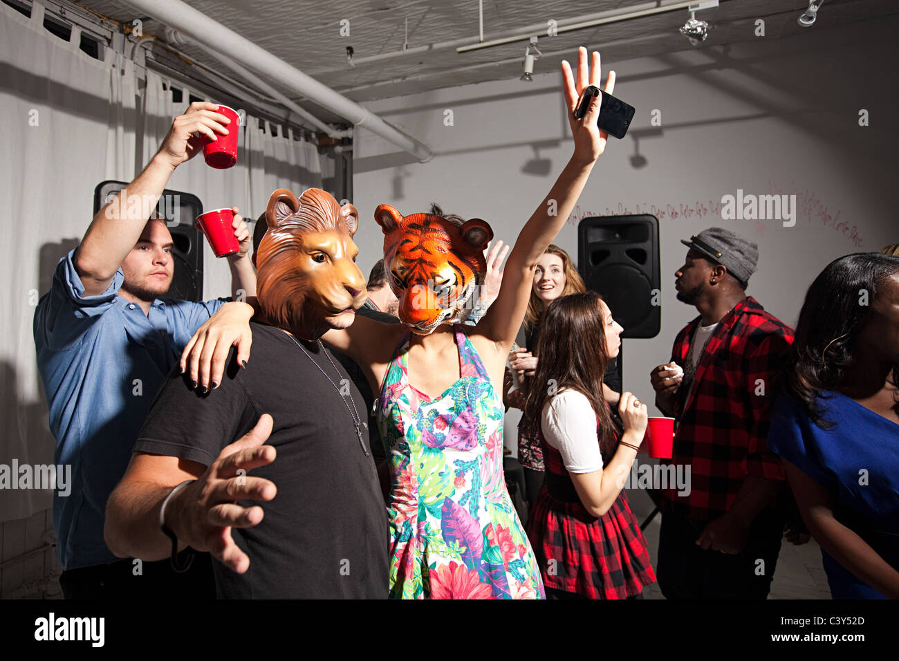People wearing lion and tiger masks dancing at party Stock Photo - Alamy