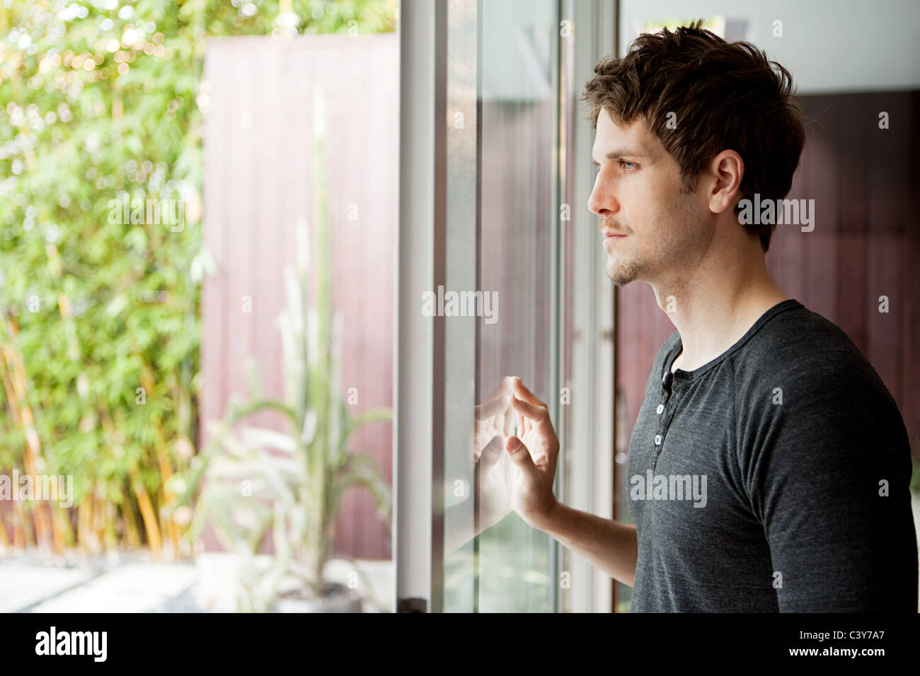 Man looking out of window Stock Photo - Alamy