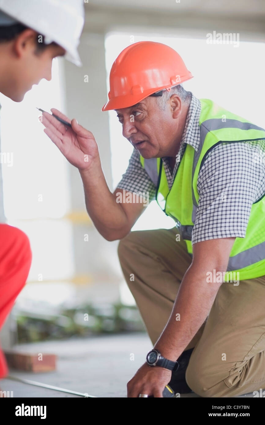 Old worker talking to young worker Stock Photo - Alamy