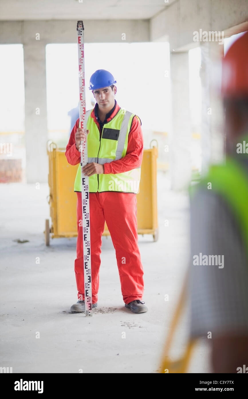 Building worker doing some measuring Stock Photo - Alamy