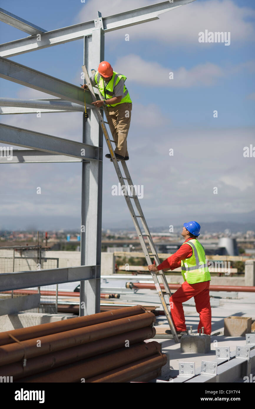 Worker standing on ladder Stock Photo - Alamy