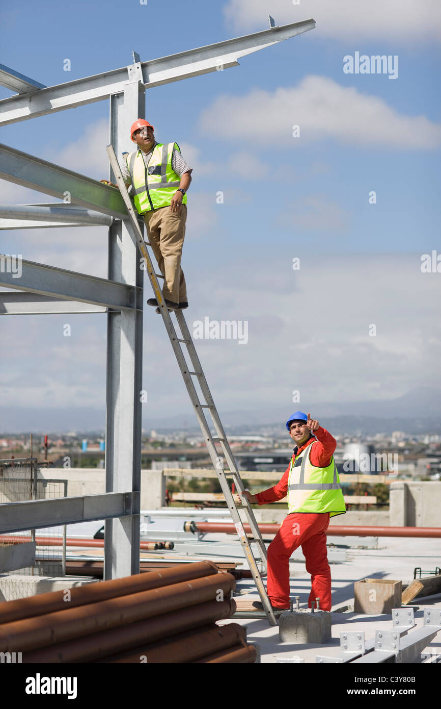 Worker standing on ladder Stock Photo - Alamy