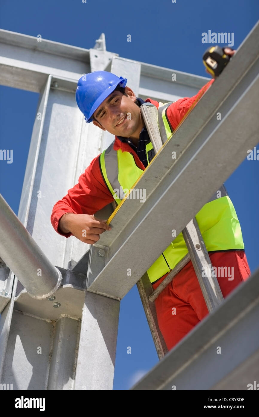 Worker standing on ladder Stock Photo - Alamy