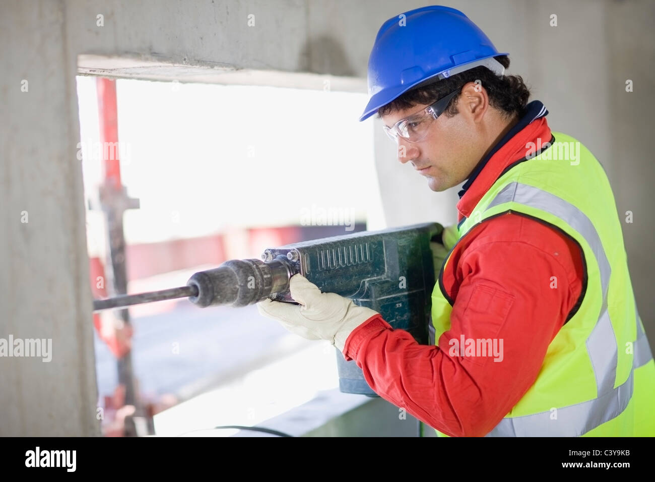 Building worker handling a power drill Stock Photo - Alamy