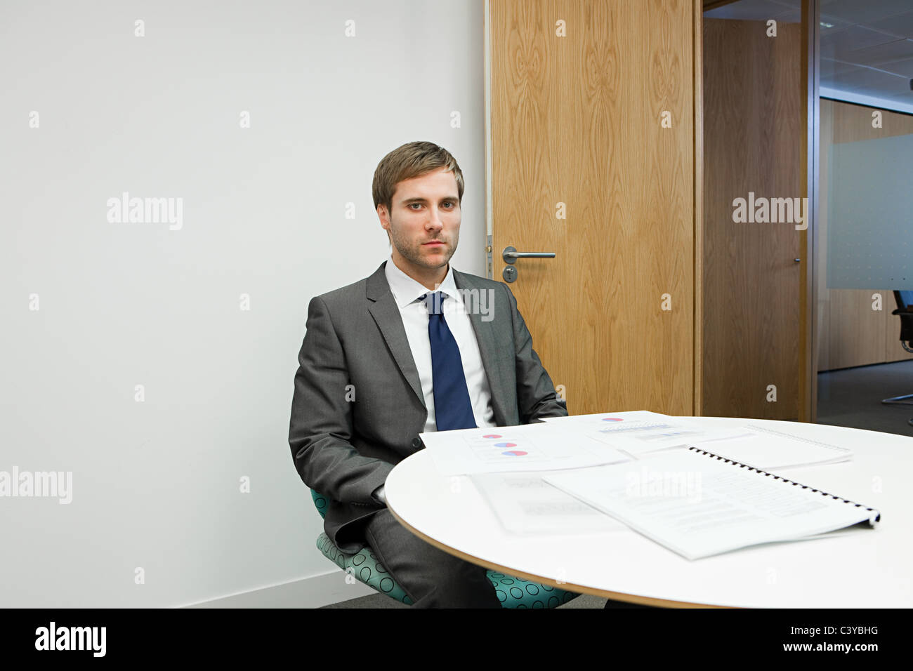 Portrait of businessman at table Stock Photo - Alamy