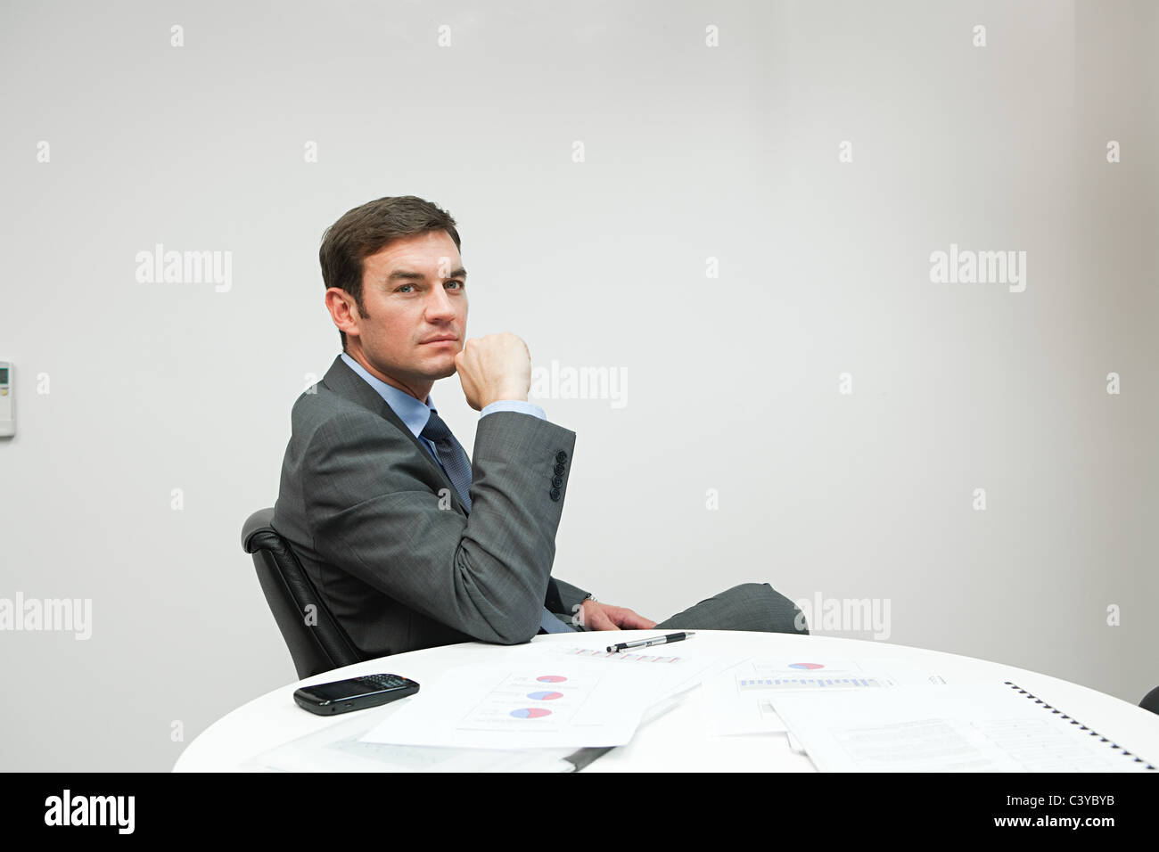 Portrait of businessman at table Stock Photo - Alamy