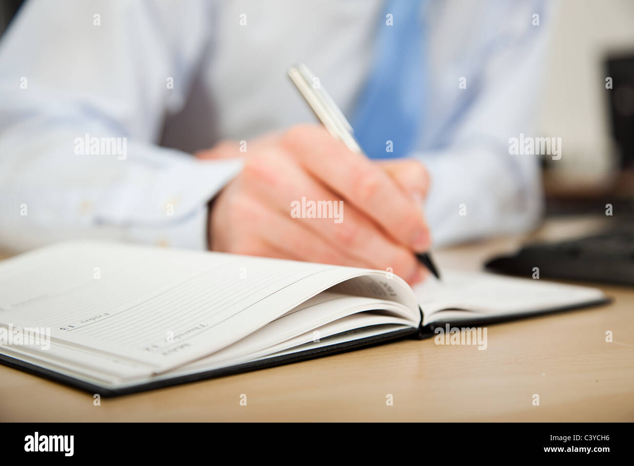 Office worker writing in diary Stock Photo - Alamy