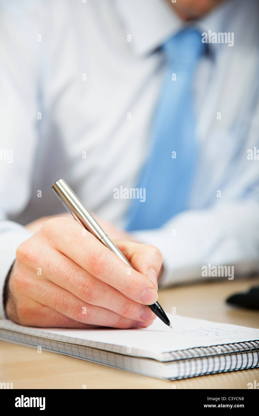Office worker making notes in notebook Stock Photo - Alamy