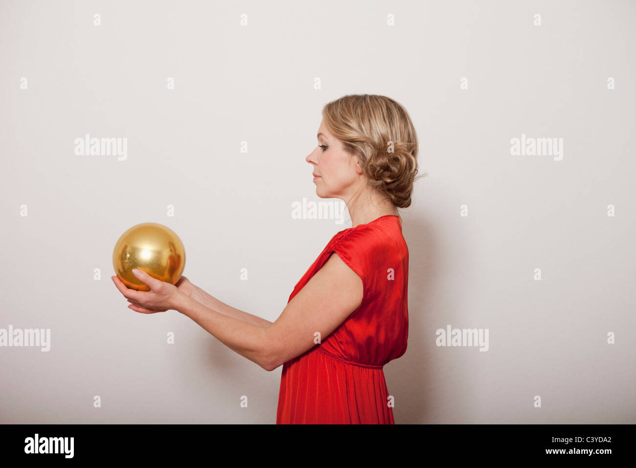 Woman holding a golden ball Stock Photo - Alamy