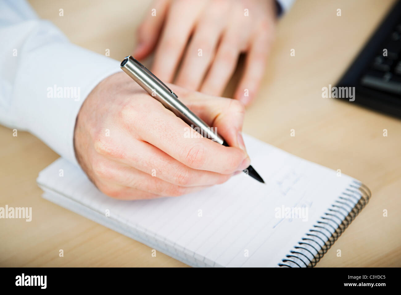 Office worker writing in notebook Stock Photo - Alamy
