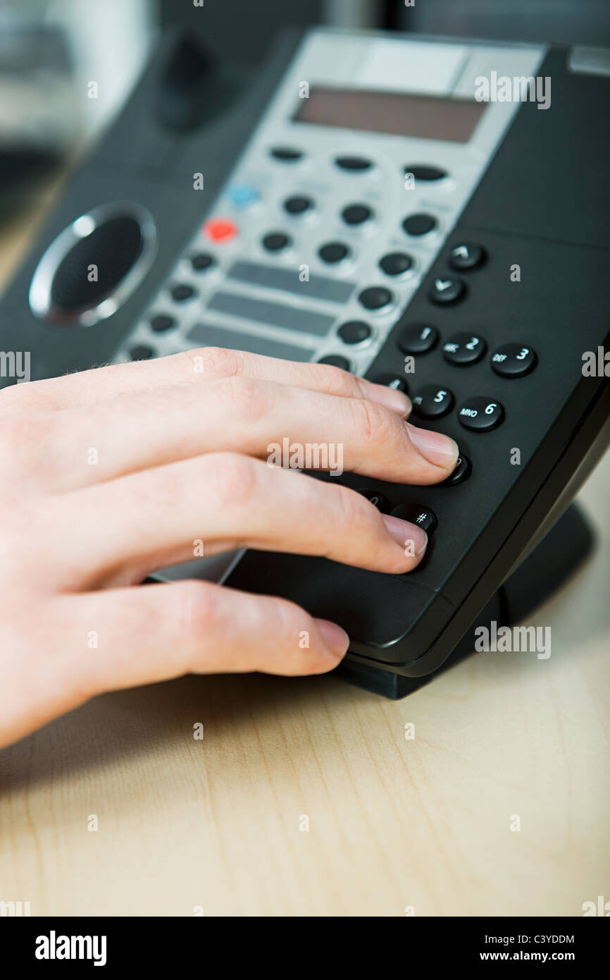 Office worker dialling telephone Stock Photo - Alamy