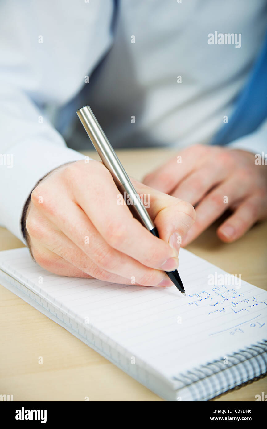 Office worker writing in notebook Stock Photo - Alamy