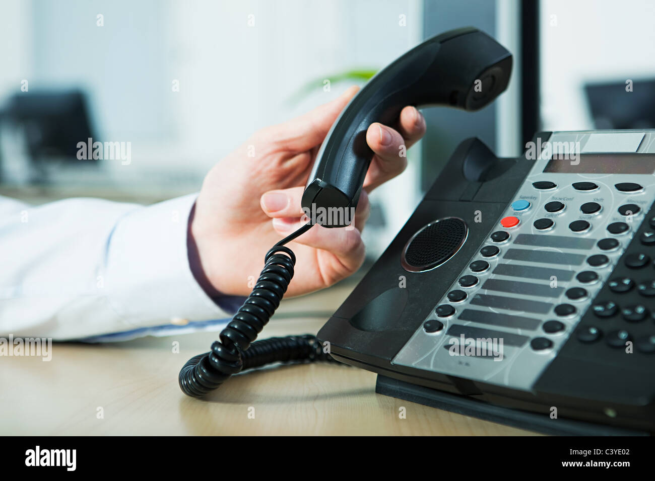 Office worker answering telephone Stock Photo - Alamy