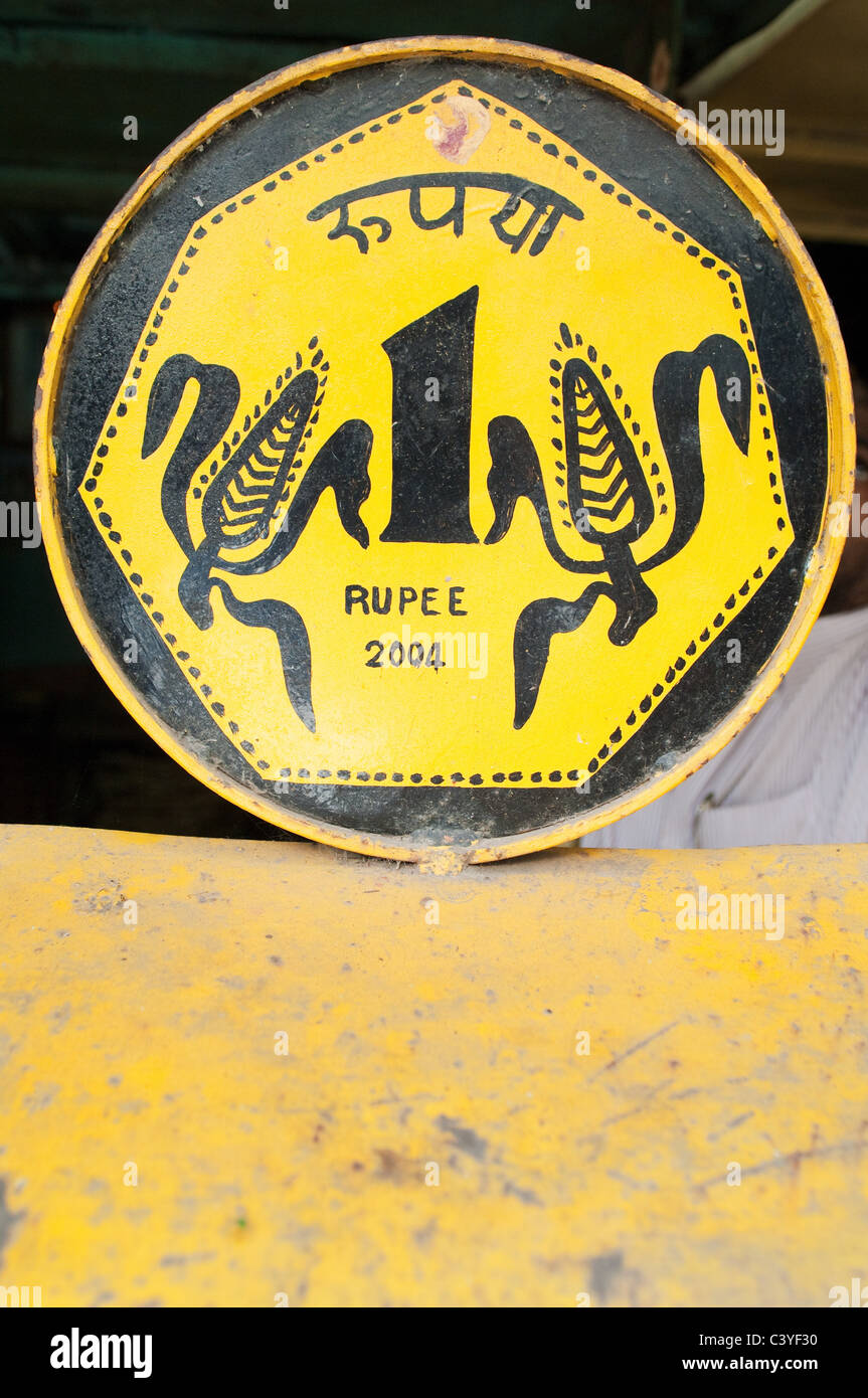 Yellow tin rupee sign for public telephone Stock Photo - Alamy