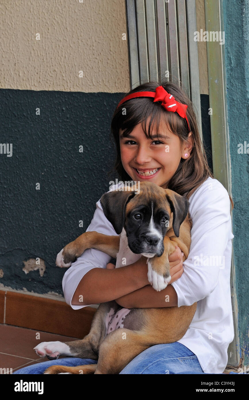 Child holding boxer puppy dog Stock Photo - Alamy