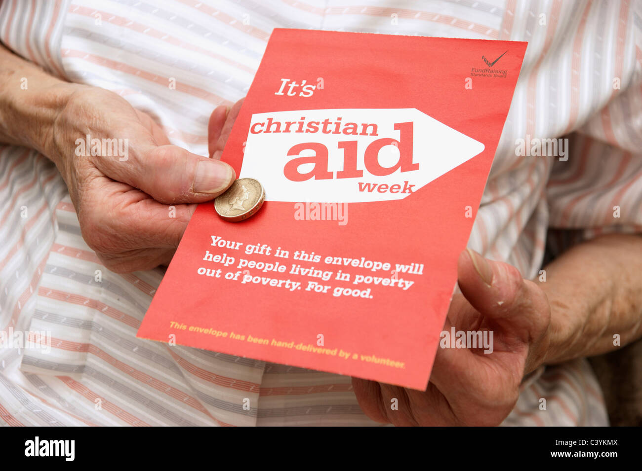 woman holding donation of a coin for a charity collecting envelope for ...