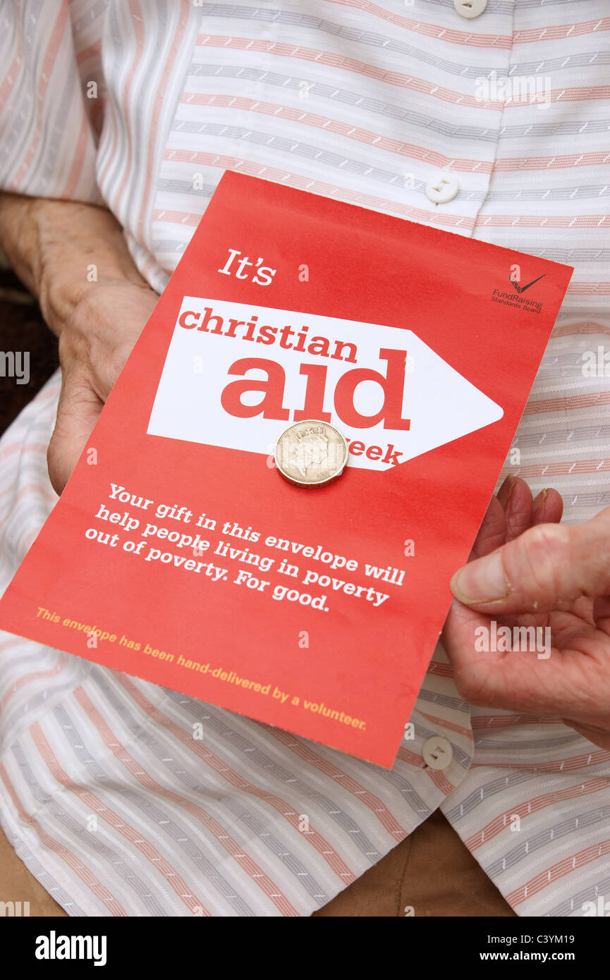 woman holding donation of a coin for a charity collecting envelope for ...