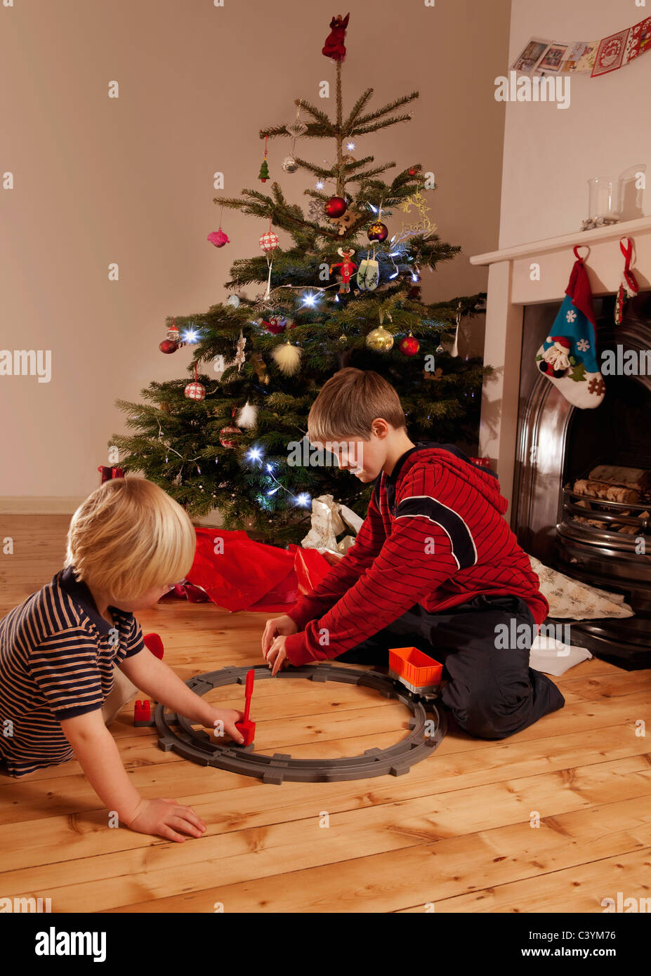 Two young boys playing with a train set Stock Photo - Alamy