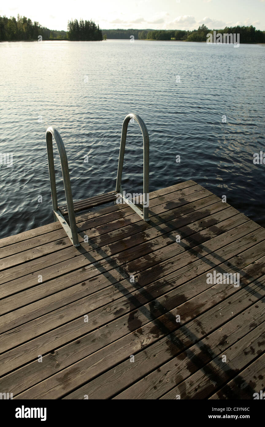 Metal ladder getting into water at end of wooden pier Amal Sweden by a ...