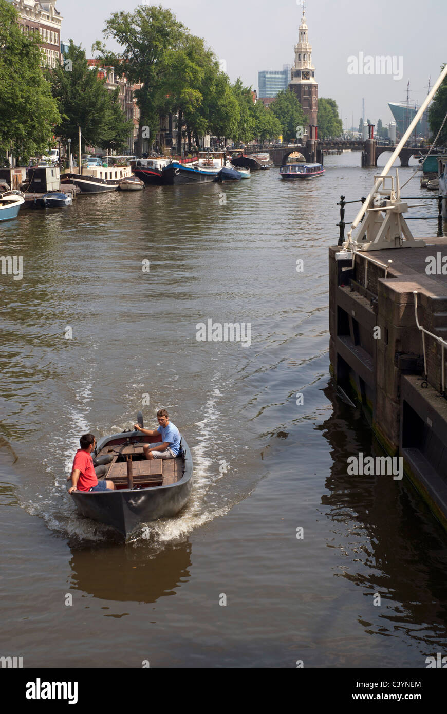 Two people in a small boat on the Oude Schans Canal in Amsterdam ...