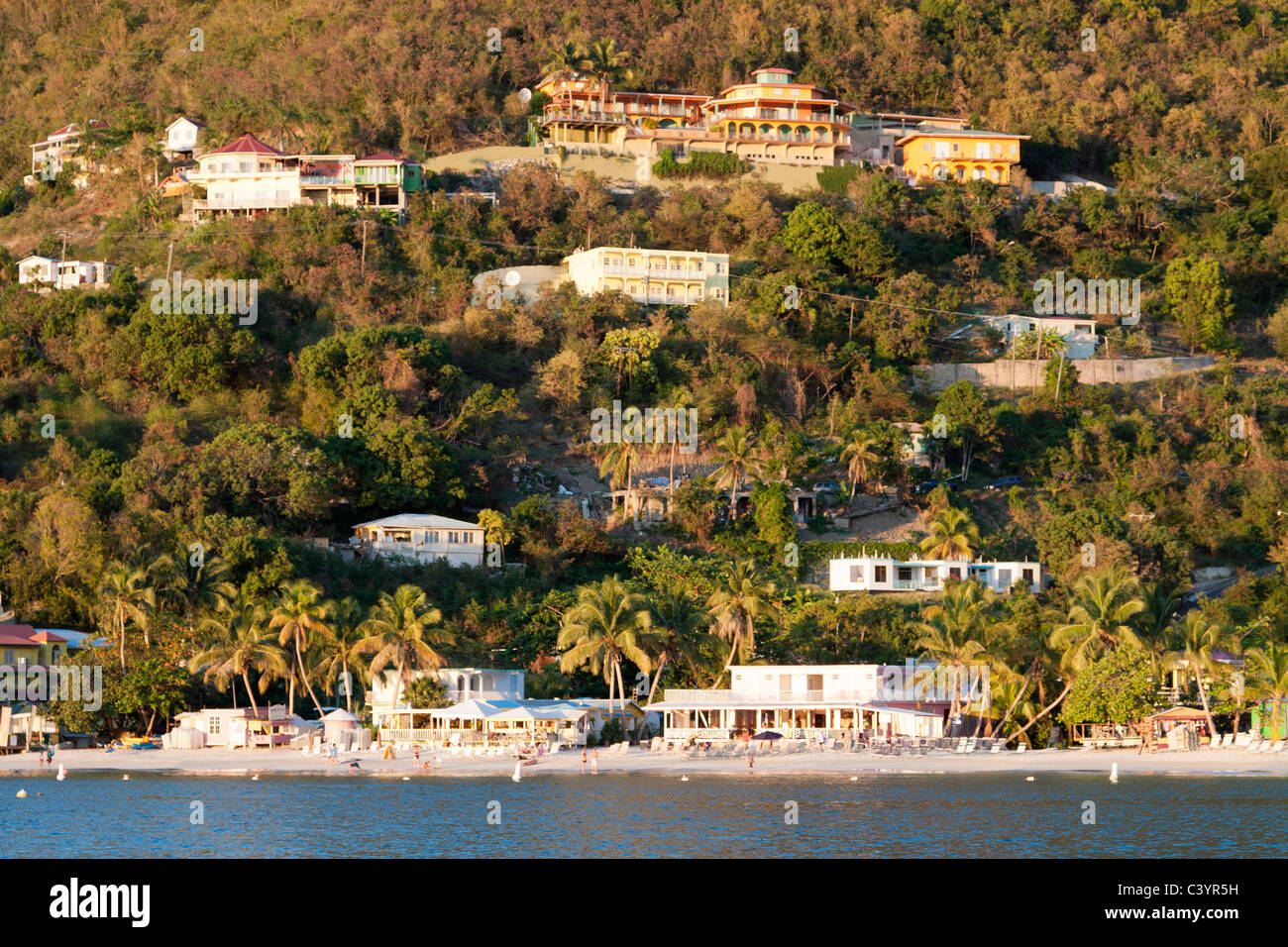 Evening glow on the pretty hillside homes perched above the beach and ...