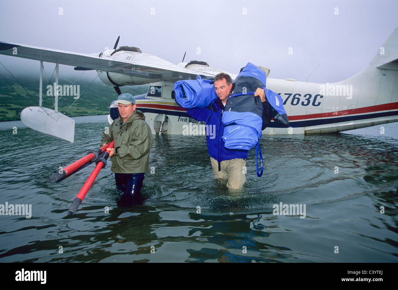 Men carrying raft from float plane Stock Photo - Alamy