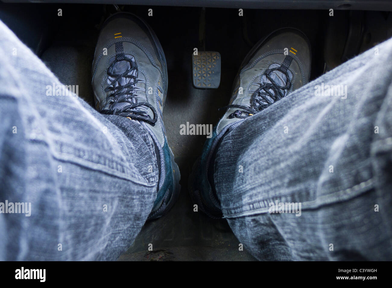 A mans feet on the foot pedals of a car driving Stock Photo - Alamy