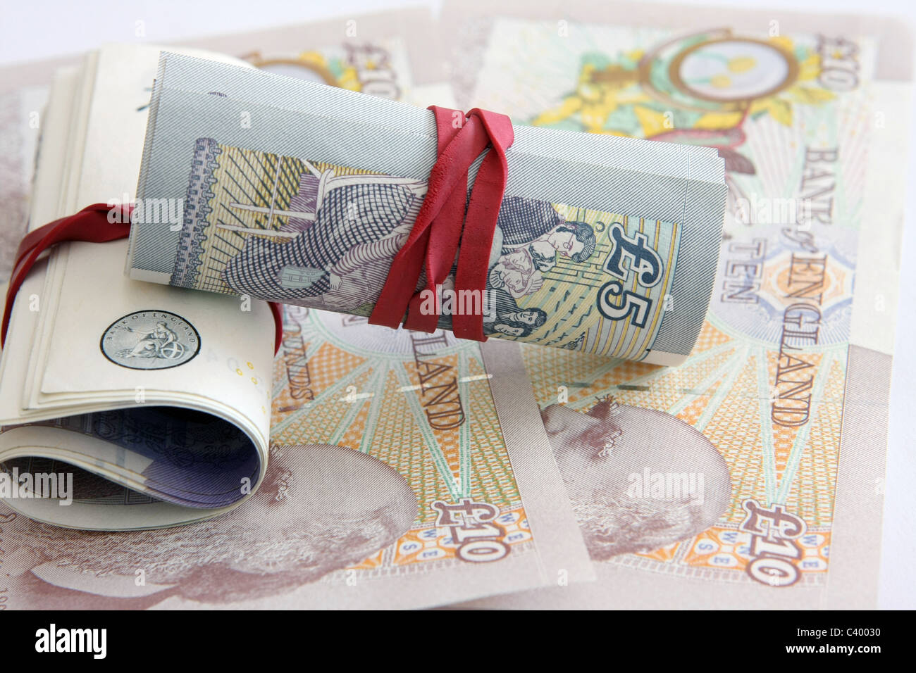 rolled up bundles of sterling £20 and £5 notes on £10 notes Stock Photo ...
