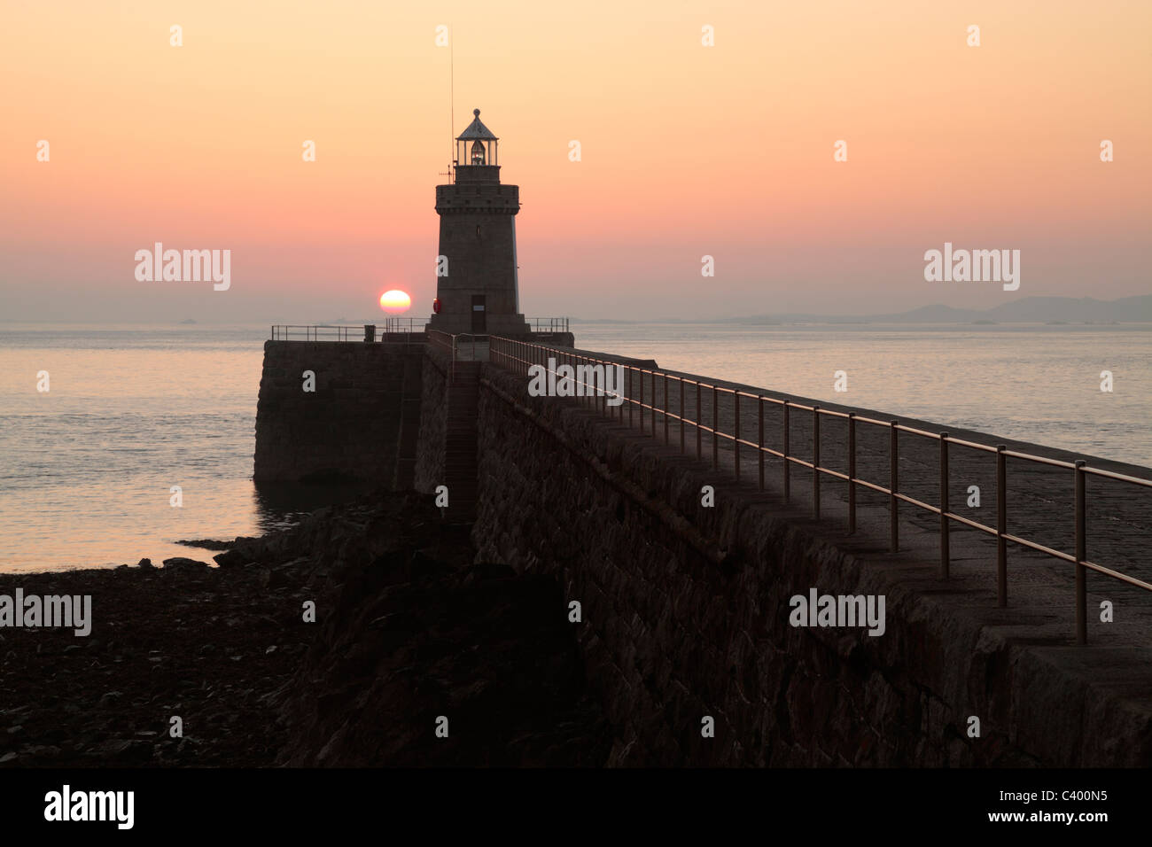 St Peters Port lighthouse at sunrise Stock Photo - Alamy